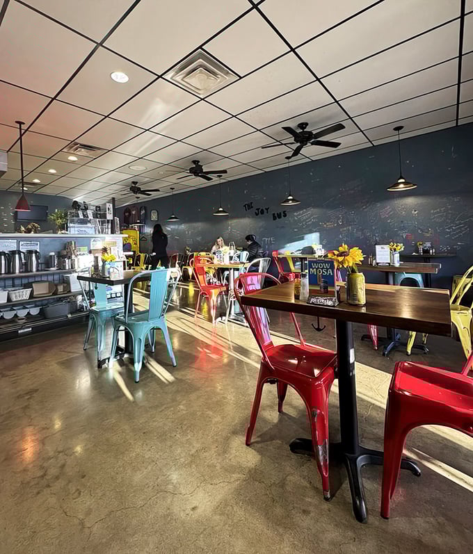 Colorful metal chairs pop against concrete floors, creating a space that feels both modern and welcoming—like your coolest friend's kitchen.