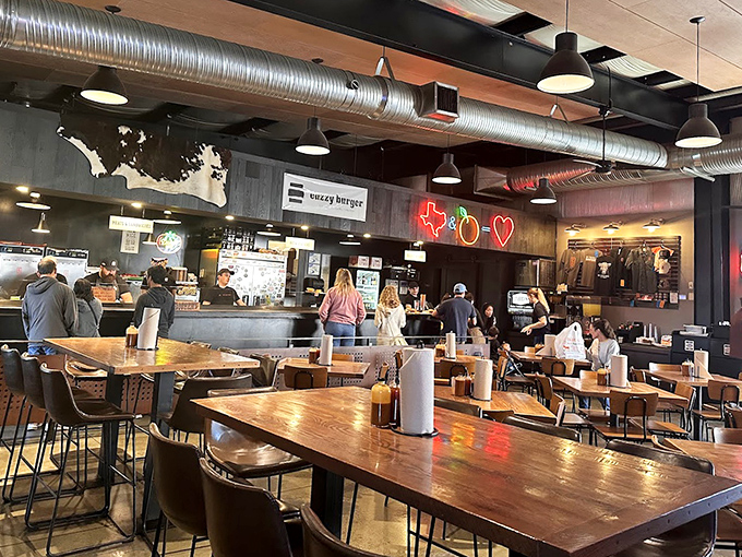 Industrial chic meets barbecue warmth inside ZZQ. That neon Texas outline isn't just decoration—it's a promise of authenticity that your taste buds will soon confirm.