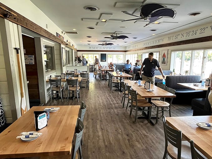 Wooden tables, nautical coordinates, and ceiling fans spinning stories of seafood feasts past and future.