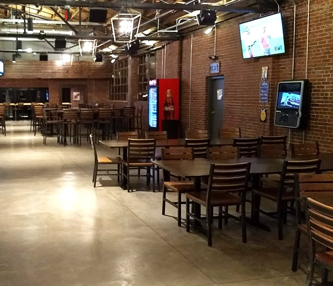 Industrial-chic meets cozy comfort inside, where exposed brick and wooden tables create the perfect backdrop for serious burger business.