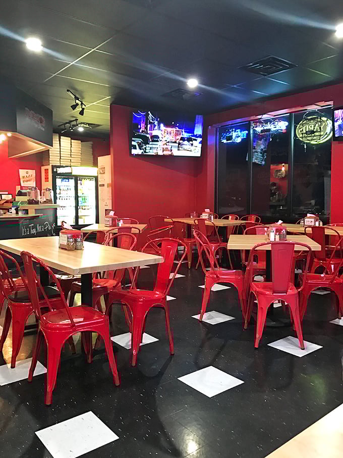 Inside, those cherry-red metal chairs pop against the checkerboard floor, creating a retro diner vibe that says, "Sit down, stay awhile, loosen that belt."