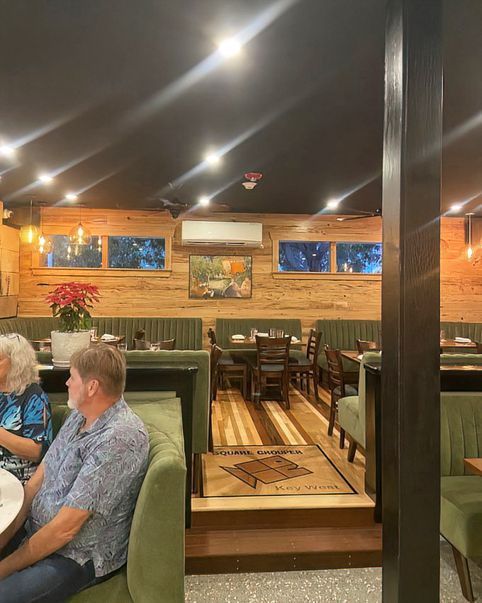 Warm wooden walls and green booth seating create the perfect backdrop for culinary magic. Comfort meets sophistication in this inviting space.