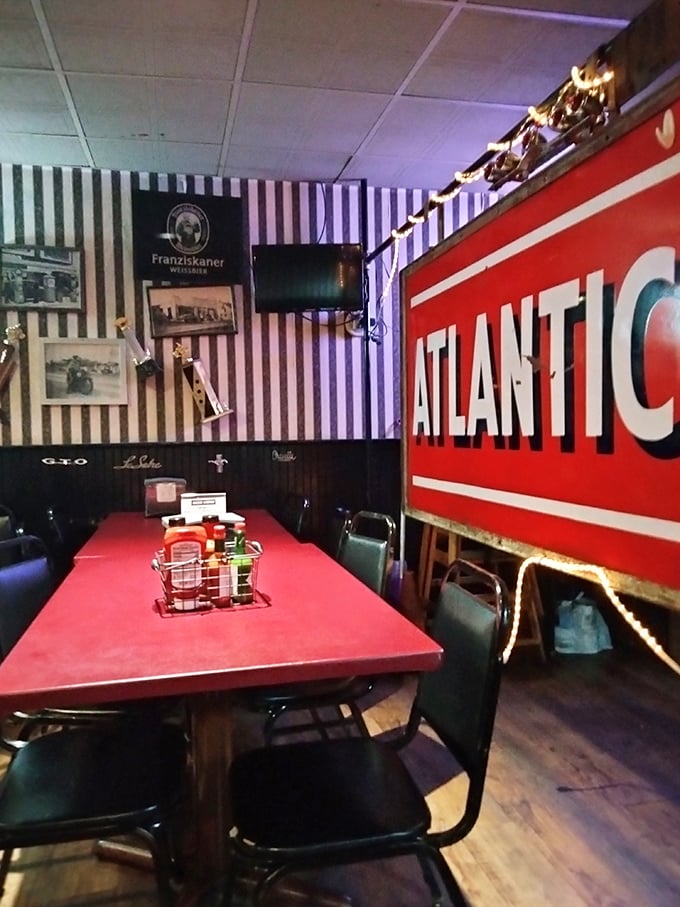 The striped walls and vintage Atlantic sign scream "authentic roadhouse" – not the kind designed by corporate suits with clipboards and focus groups.