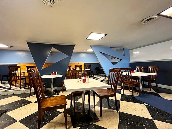 The geometric blue panels and classic checkered floor create a retro-futuristic vibe that feels like dining in a 1960s vision of a space-age diner.