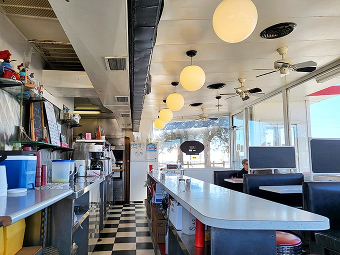 Classic checkered floors and globe lights create the quintessential American diner atmosphere – where conversations flow as freely as the coffee.