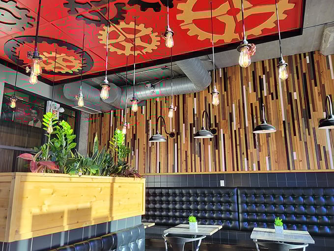 The ceiling's vibrant gear motif and warm wooden accents create an atmosphere that's equal parts industrial chic and neighborhood cozy—like a hug from a very stylish friend.