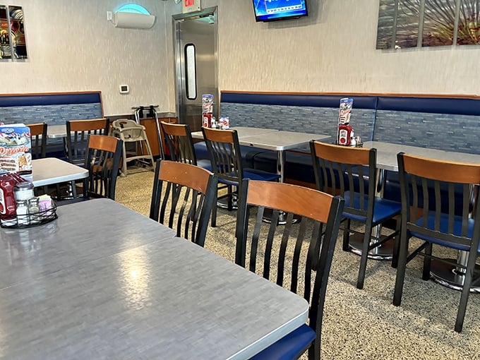 Inside, that perfect diner atmosphere awaits – wooden chairs, blue upholstery, and tables arranged just right for both privacy and people-watching.