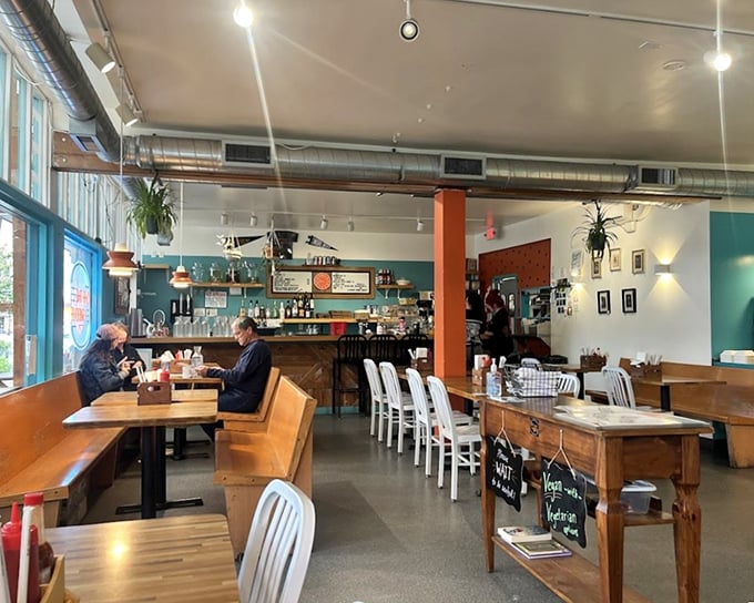 Inside, wooden tables and white chairs create a cozy haven where industrial meets homey—the perfect backdrop for comfort food conversations.