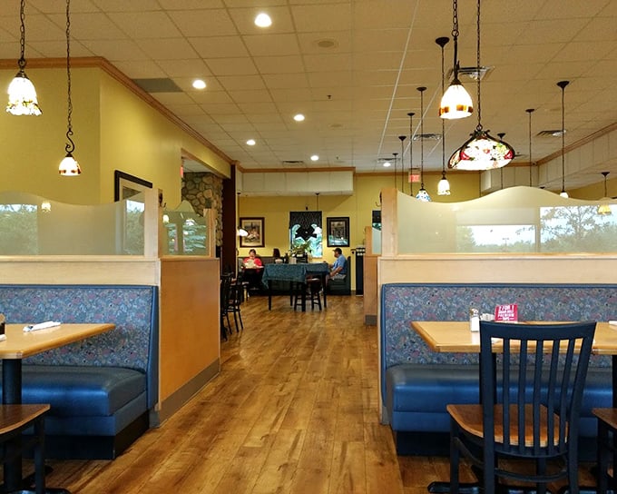 Inside Carol's, Tiffany-style pendant lights cast a warm glow over blue booths and wooden floors—the perfect backdrop for Minnesota's ultimate comfort food experience.