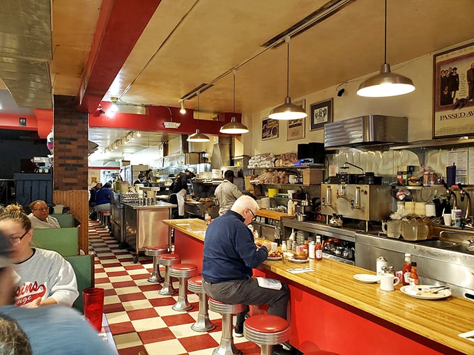 Classic diner perfection: red and white checkerboard floors, counter seating where regulars become family, and the symphony of sizzling breakfast.