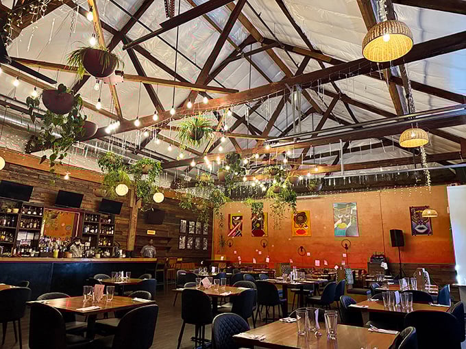 High ceilings, hanging plants, and warm lighting create the perfect atmosphere for a culinary adventure – part industrial chic, part tropical oasis.