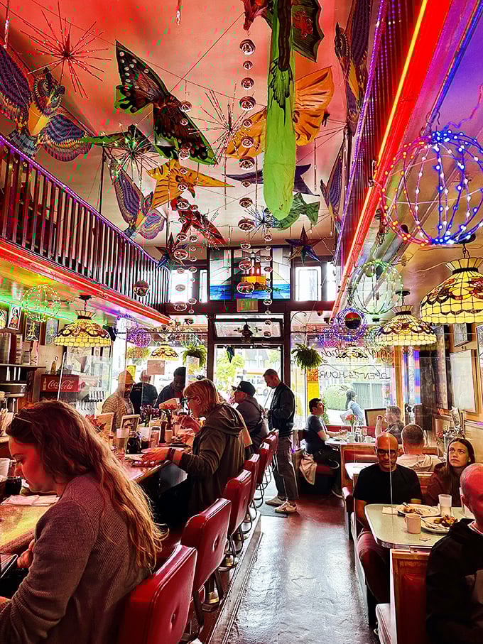 Step inside and look up—this isn't just a diner, it's a kaleidoscopic wonderland where kites and disco balls dance overhead while pancakes sizzle below.
