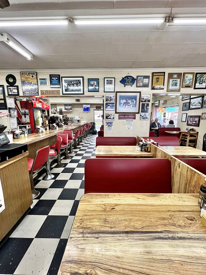 Classic red vinyl booths, checkered floors, and walls filled with memories—this isn't interior design, it's BBQ history in physical form.