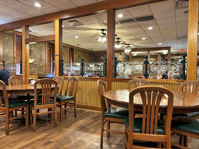 Wooden booths and chairs with green cushions create that perfect diner atmosphere—where conversations flow as freely as the coffee.