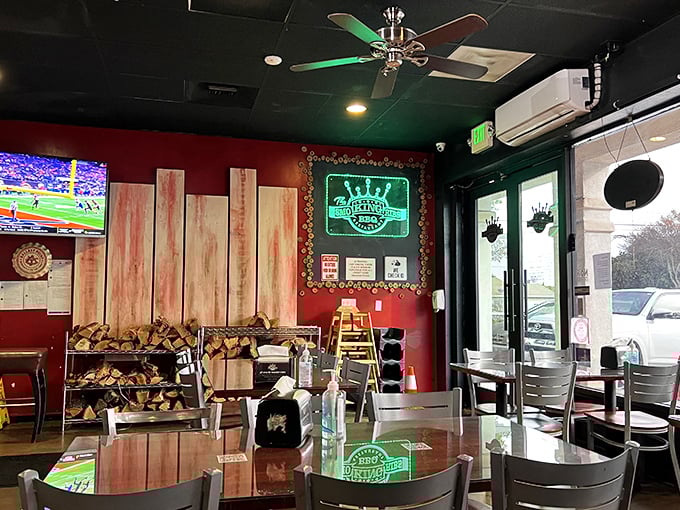 Stacked firewood isn't just decor—it's a promise of authentic smoking. The red walls and neon sign set the stage for meat magic.