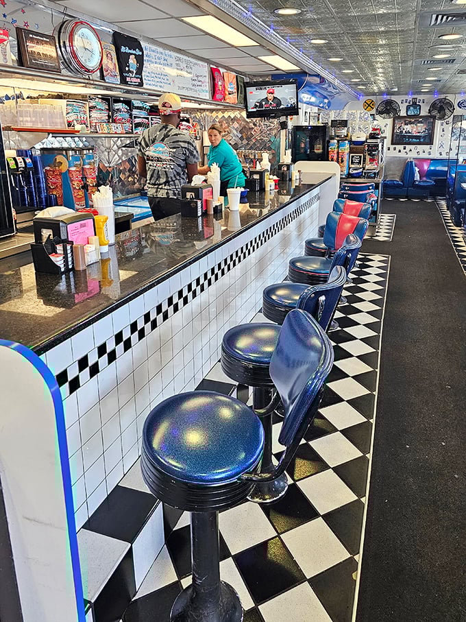 Classic black and blue vinyl stools line a counter where regulars perch like birds on a diner wire.