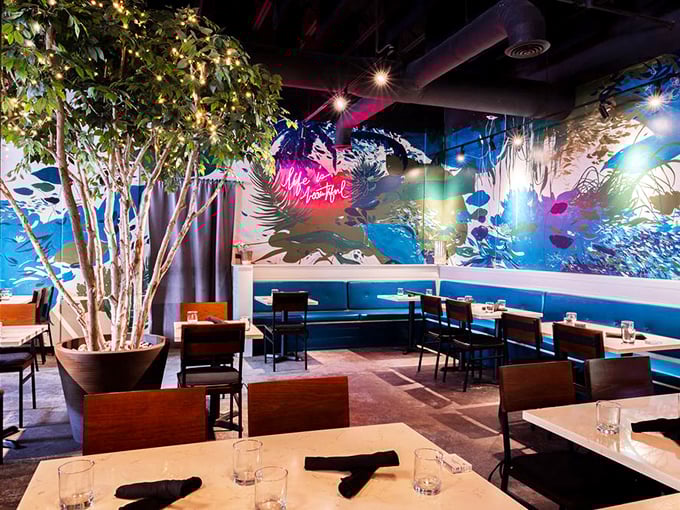 Step inside to discover a dining room where nature meets art—that stunning blue mural and indoor tree create an atmosphere that's both energizing and soothing.