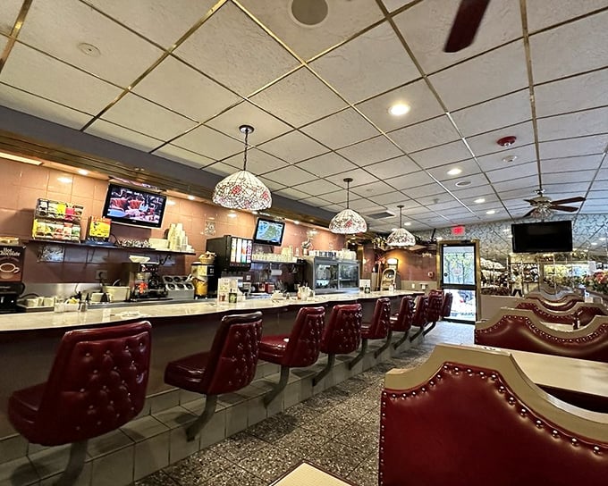 The counter where dreams are made—those burgundy stools have witnessed first dates, business deals, and countless "just one more coffee" moments.