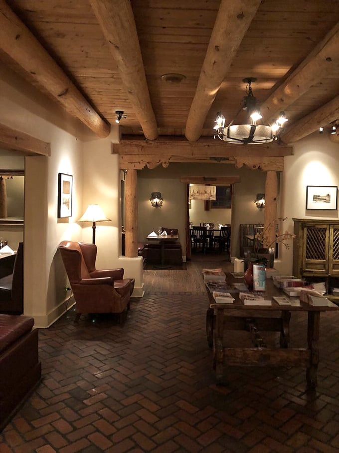 The warm glow of wooden vigas and brick floors welcomes you like an old friend. This isn't just a waiting area—it's the prelude to a memorable meal.