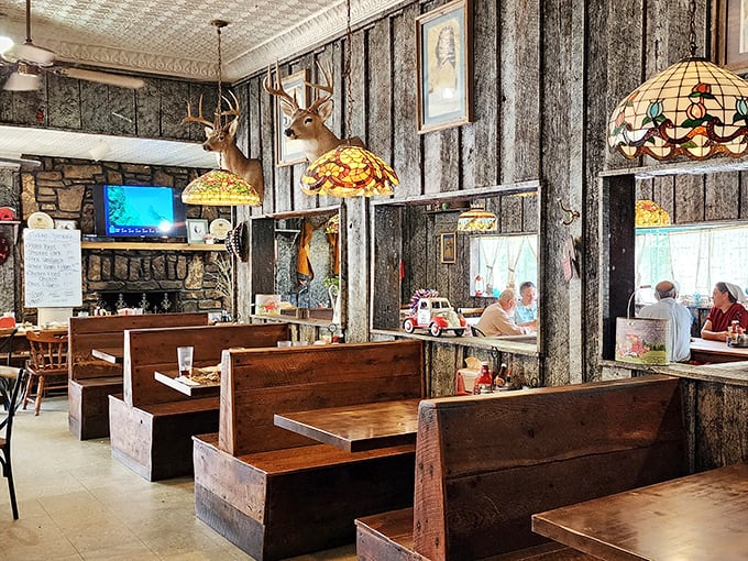 Step inside and you're transported to a simpler time – deer head lamps illuminate church pew booths while the pressed tin ceiling whispers stories of meals past. 