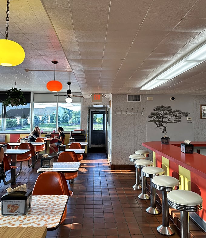 Orange chairs, pendant lights, and counter stools straight from the Kennedy era—this isn't retro by design, it's authentic by survival.