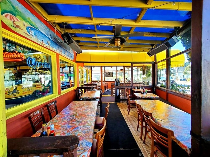 Colorful tablecloths and wooden chairs create that perfect "I've discovered something special" atmosphere. The blue ceiling beams? Pure coastal charm without trying too hard.