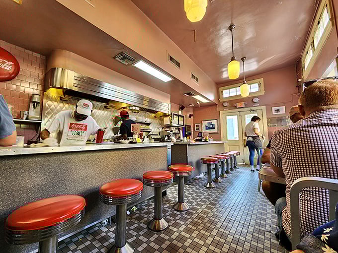 Diner perfection: Red vinyl stools, checkered floors, and cooks working their magic behind the counter – this is breakfast theater at its finest.