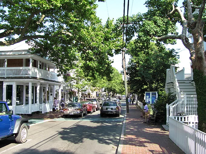 Main Street's canopy of elms creates dappled sunlight on brick sidewalks, while white-trimmed shops stand like a Hollywood set designer's dream of small-town America.