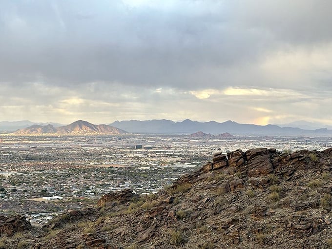 Mother Nature's own IMAX experience – Phoenix unfolds beneath moody skies, with distant mountains standing like silent guardians of the valley.