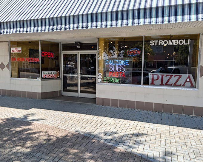 La Vera's striped awning and neon signs promise old-school pizza goodness – the kind that makes you nostalgic for places you've never been.