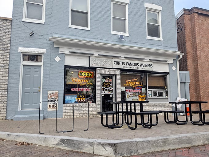 Curtis Famous Weiners' bright blue storefront pops against the brick buildings, a century-old hot dog haven still drawing loyal fans.