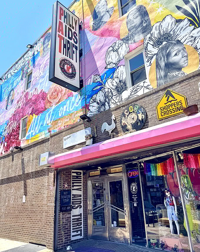 Philly AIDS Thrift exterior wide view: "A rainbow explosion of color and cause. This isn't just a thrift store—it's a Philadelphia landmark with purpose."