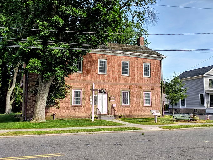 This perfectly preserved brick colonial stands like a time capsule, its white door welcoming visitors just as it did centuries ago.