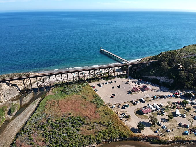 That pier stretching into the Pacific like California's wooden handshake with the ocean – authentic, weathered, and absolutely magnificent.