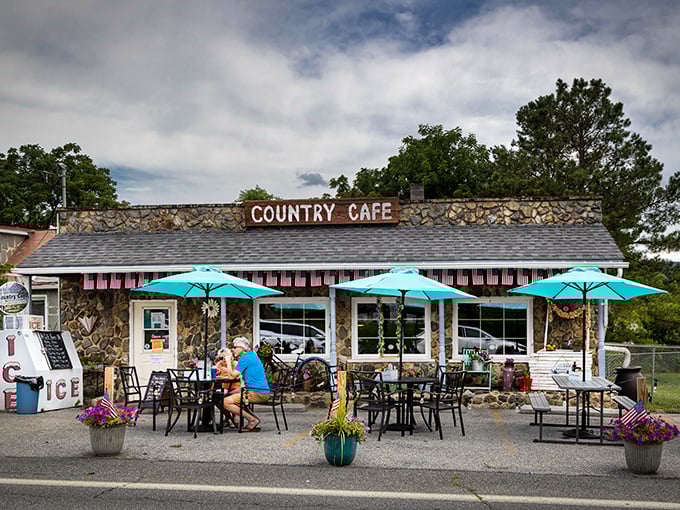 The Country Café's stone exterior promises comfort food that hugs your insides, while those turquoise umbrellas beckon like old friends on a sunny day.