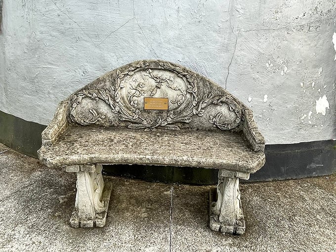 This ornate stone bench isn't just functional—it's a time capsule of craftsmanship, offering weary travelers a moment of rest against the Coffee Pot's curved wall.