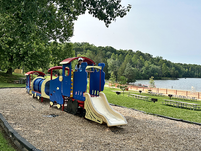 This blue train playground might be for kids, but admit it—you're calculating if you could fit down that slide too.