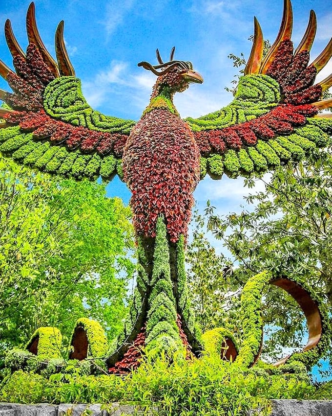 This isn't your average phoenix—it's a botanical masterpiece rising from beds of flowers instead of ashes, its wings spread in vibrant botanical plumage.