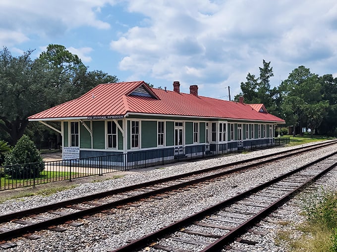 The historic L&N Train Depot stands as a crimson-roofed reminder of when travel was an event, not just transportation.