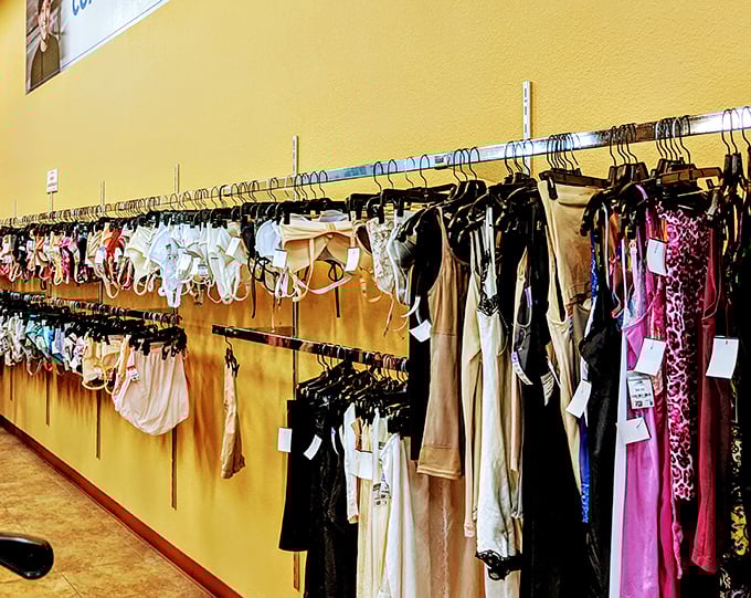 Color-coordinated clothing racks against cheerful yellow walls make browsing feel less like hunting and more like shopping.