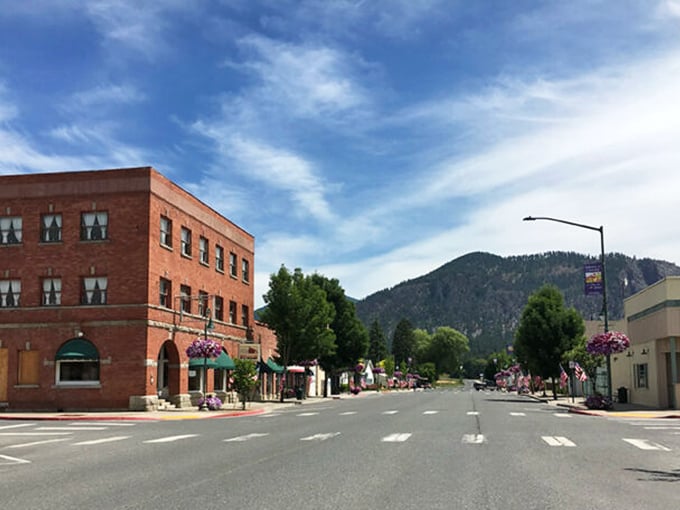 Brick buildings bathed in mountain majesty – Chewelah blooms with hanging flowers while that peak stands guard.