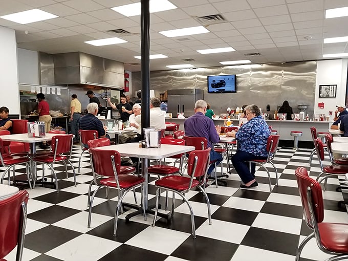 Black and white checkered floors, cherry-red chairs—this place is serving nostalgia alongside those perfect hot dogs.