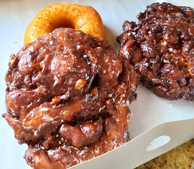 The legendary apple fritters—irregular masterpieces of crispy exterior and tender, apple-studded interior. Worth every calorie and possibly a detour from your diet.