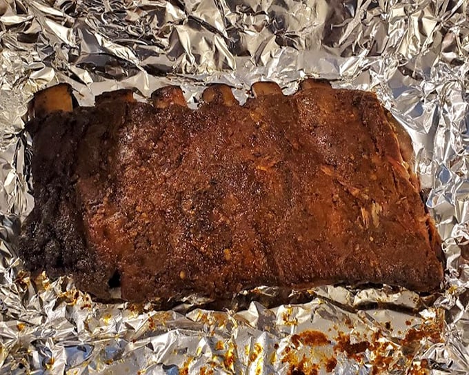 These ribs don't just have a smoke ring—they've got a full smoke halo, the kind that makes you temporarily forget your table manners.