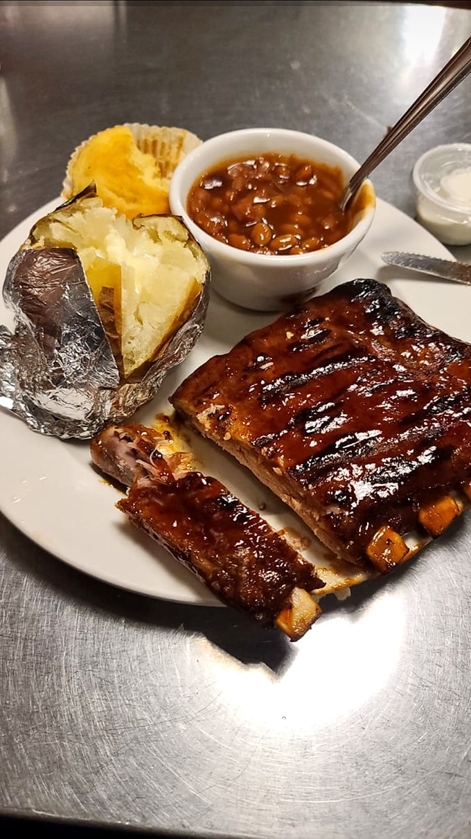 These ribs don't just fall off the bone—they practically leap into your mouth, bringing along their baked potato and beans companions for the ride.