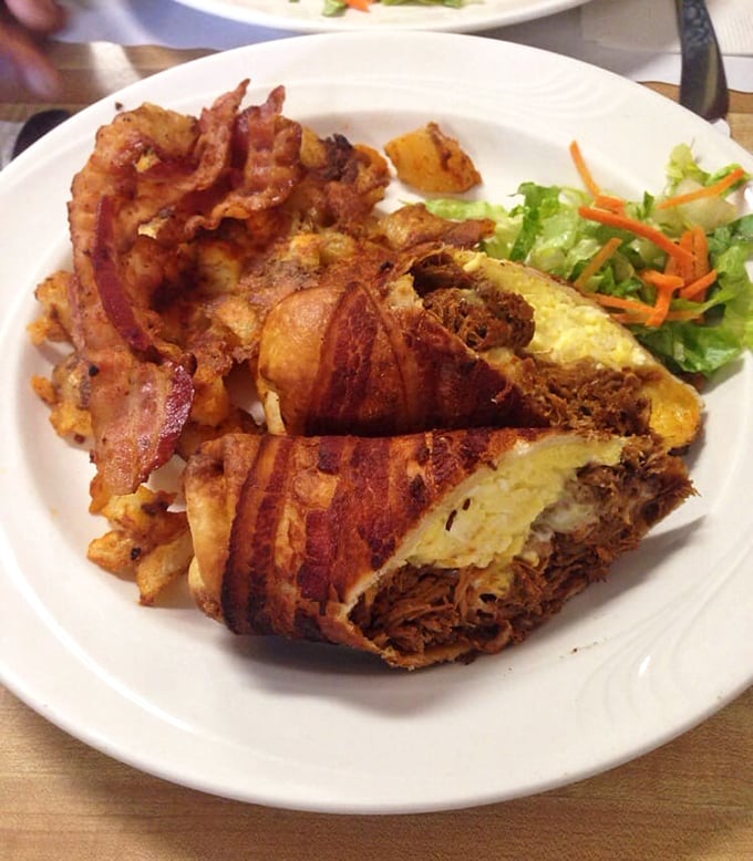 Bacon-wrapped pulled duck nestled against crispy home fries – when breakfast decides to dress up for the occasion.