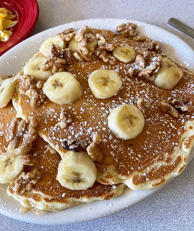 Banana walnut pancakes that don't just satisfy hunger—they solve existential crises. The powdered sugar snowfall is just showing off.