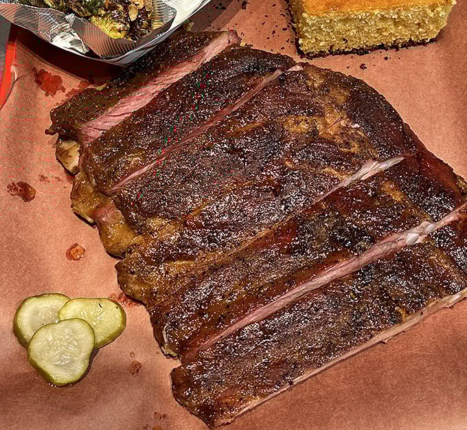 These ribs don't just fall off the bone – they practically leap into your mouth, their smoke ring telling tales of patient, masterful cooking.