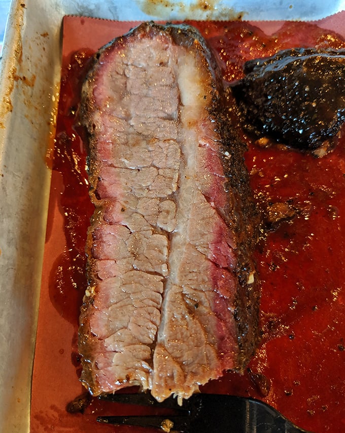 Behold the holy grail of Texas barbecue—brisket with a perfect smoke ring, rendered fat that glistens like jewelry, and bark so beautiful it belongs in a museum.
