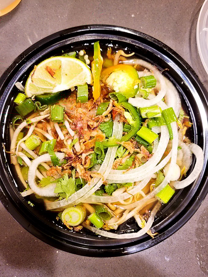Behold the crown jewel: a steaming bowl of pho where thin-sliced onions, vibrant herbs, and tender noodles swim in a broth worth crossing state lines for.